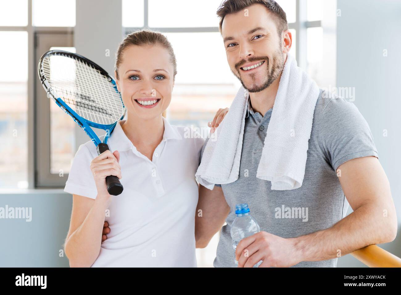 Sporty couple. Cheerful young sporty couple bonding to each other and ...