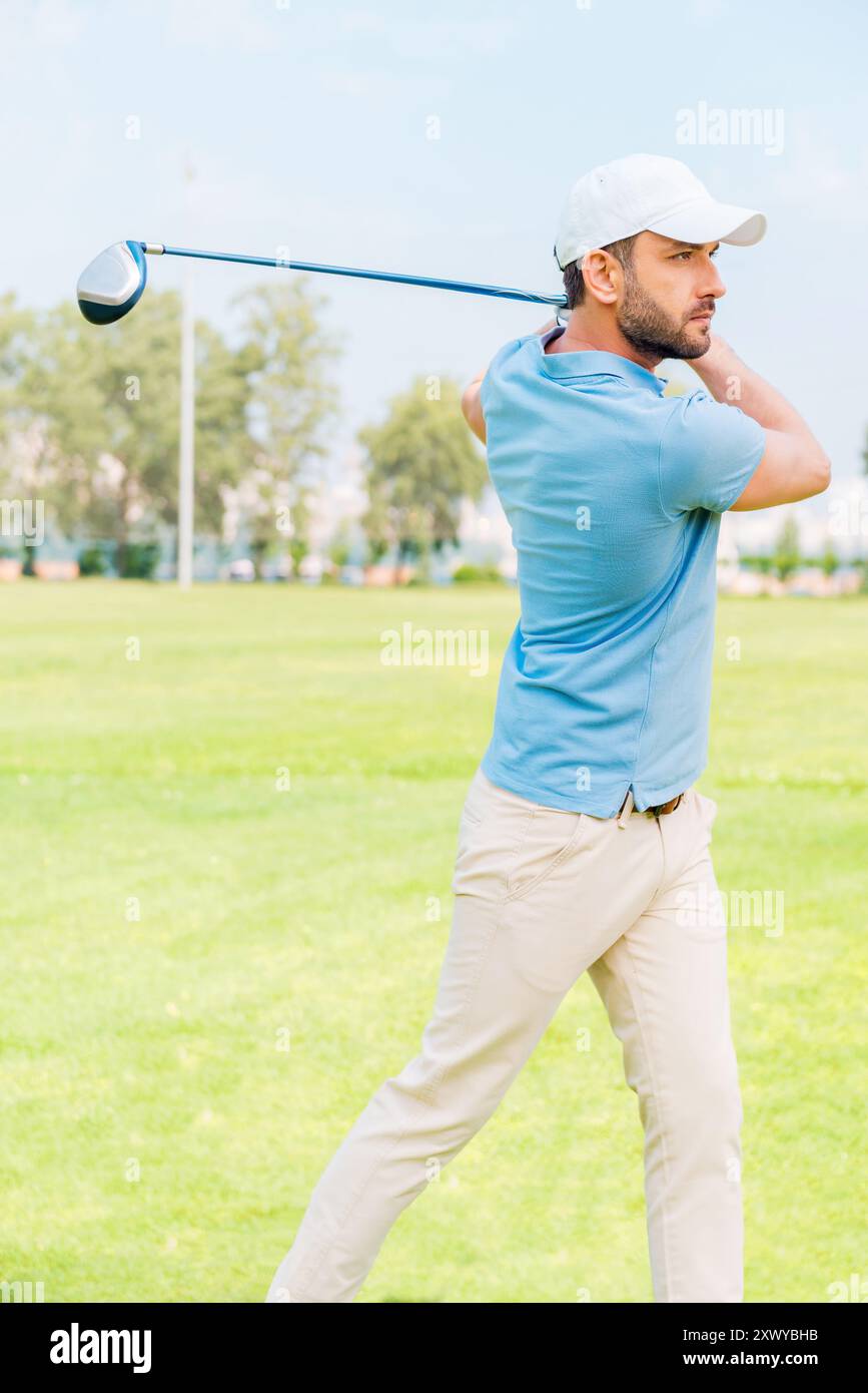 Professional golfer. Confident young man playing golf while standing on ...