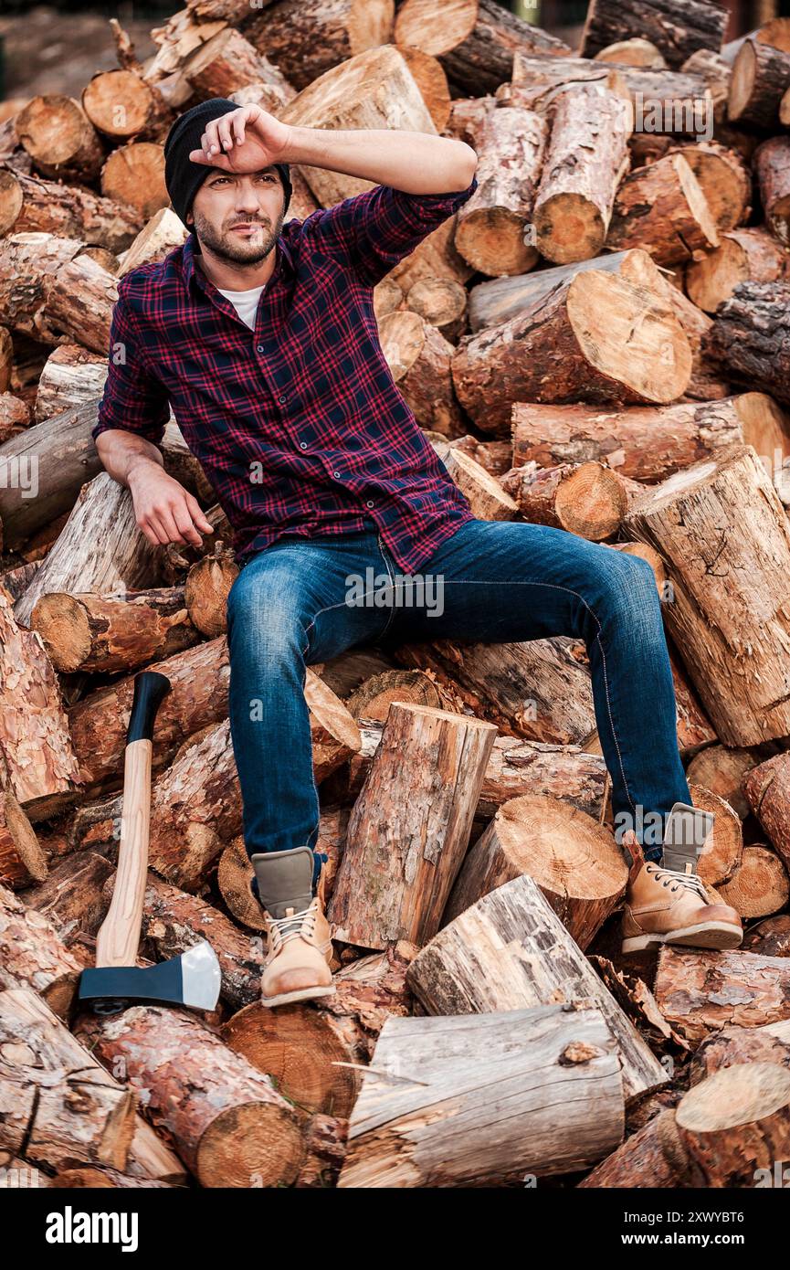 Tired after hard work. Full length of tired young forester touching his ...