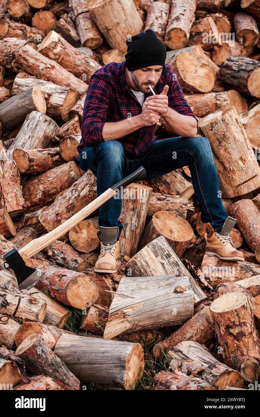 Smoking break. Full length of confident young forester smoking while ...