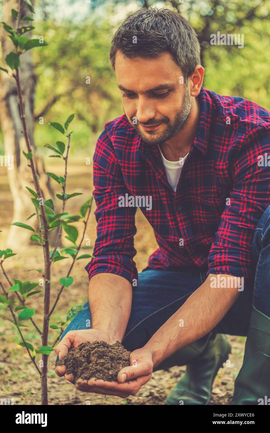 It is good soil. Confident young man holding ground and looking at it ...