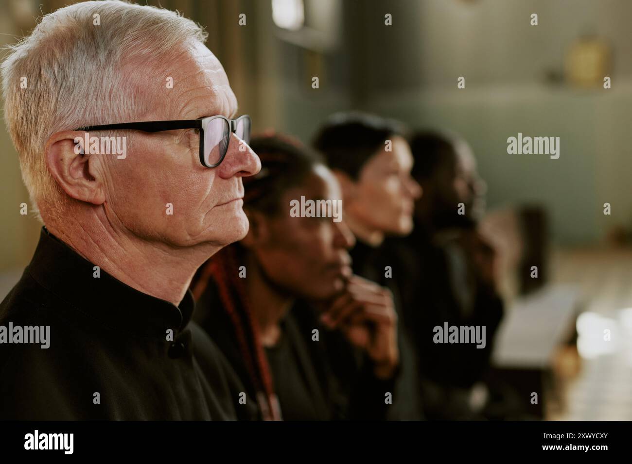 Medium close up of silver-haired pastor profile during burial service ...