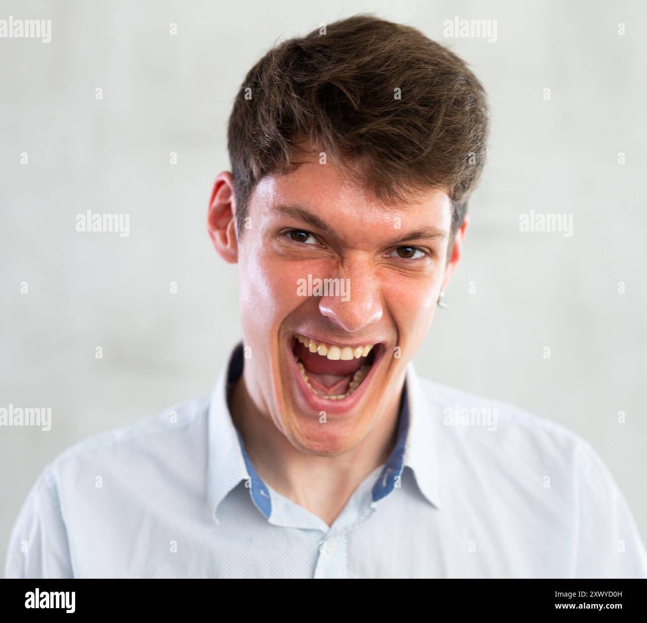Portrait of an angry man on gray background Stock Photo - Alamy
