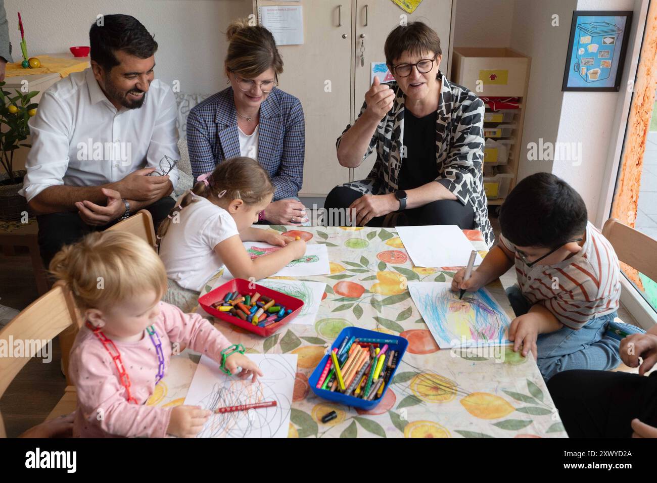 v.l. Serdar YUEKSEL, Sarah PHILIPP und Saskia ESKEN schauen Kindern ...