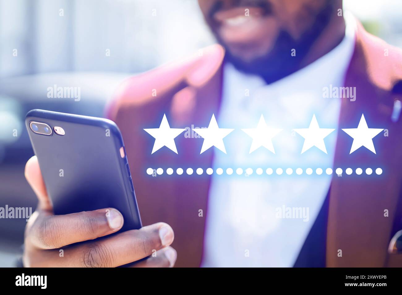 A man is holding a cell phone with a smile on his face Stock Photo - Alamy