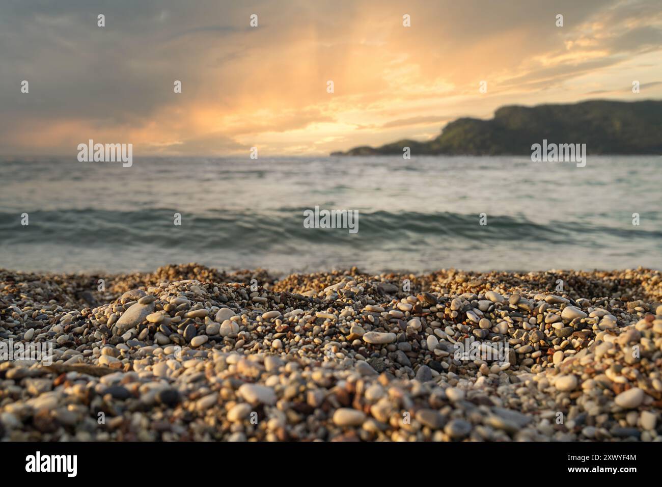Blurred beach background, nature of summer gravel beach. Sea water and ...