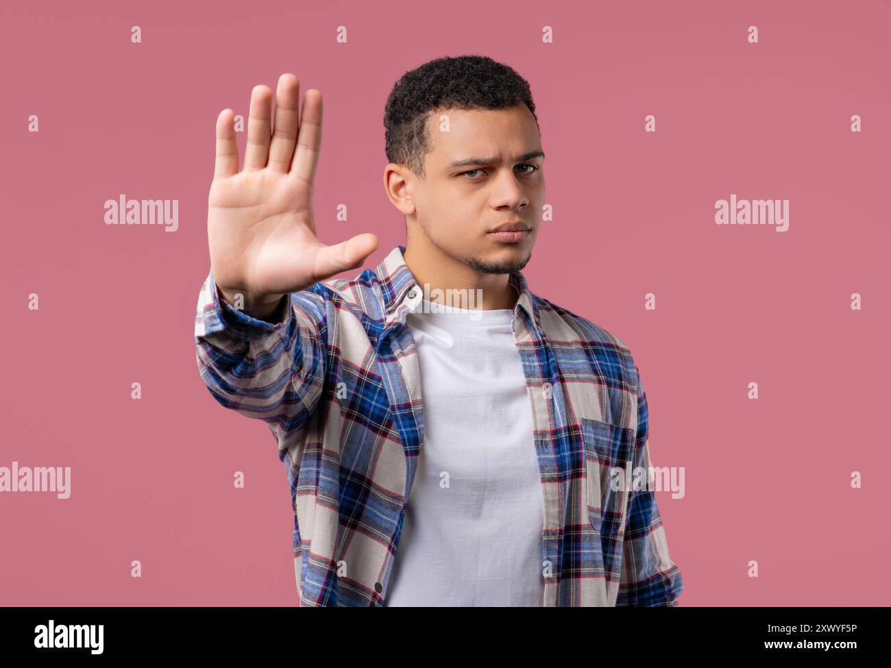 Serious man showing rejecting gesture by stop palm sign. Not allow ...