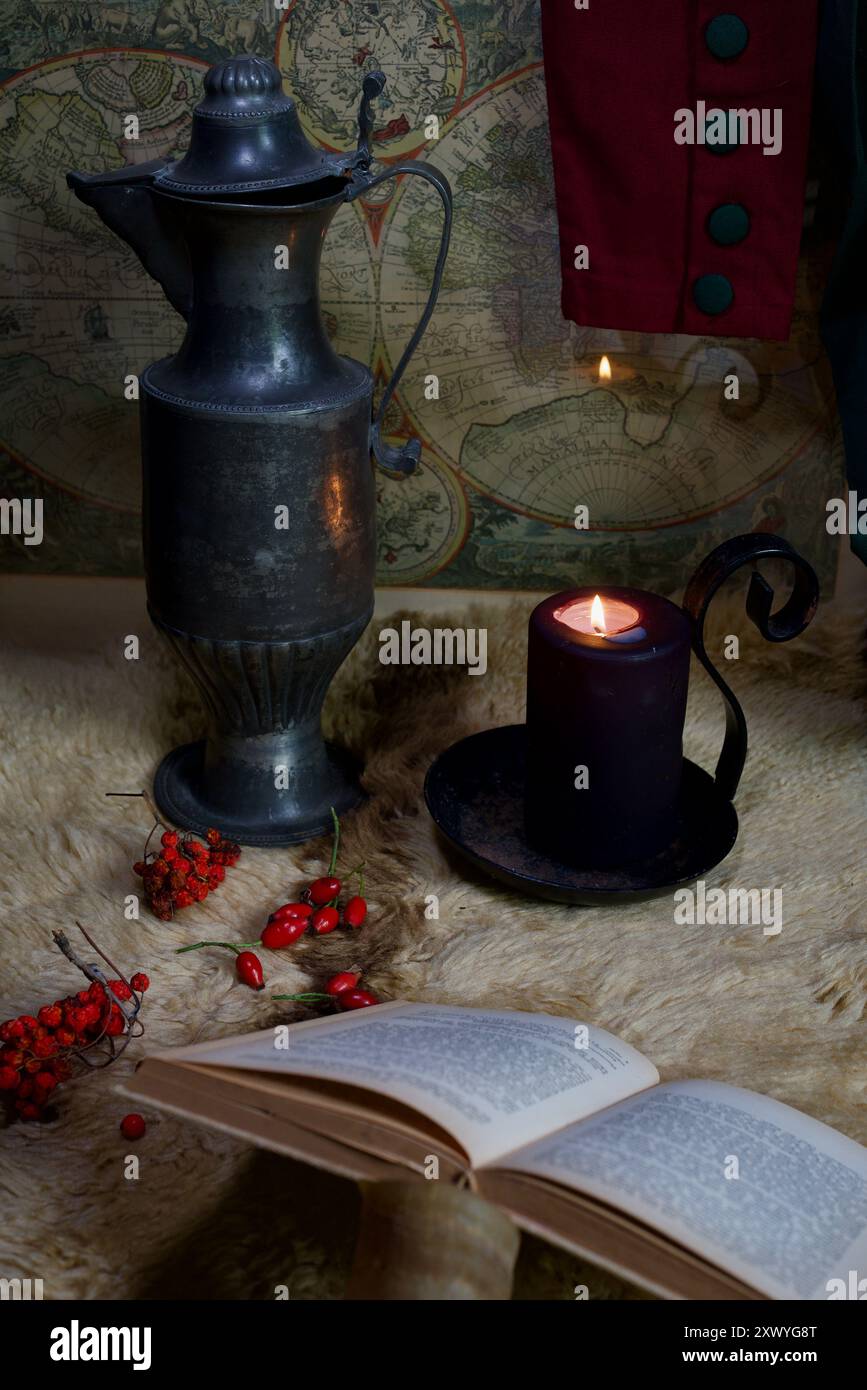 An antique jug, a black candle, berries, a book, a map, sheepskin Stock ...