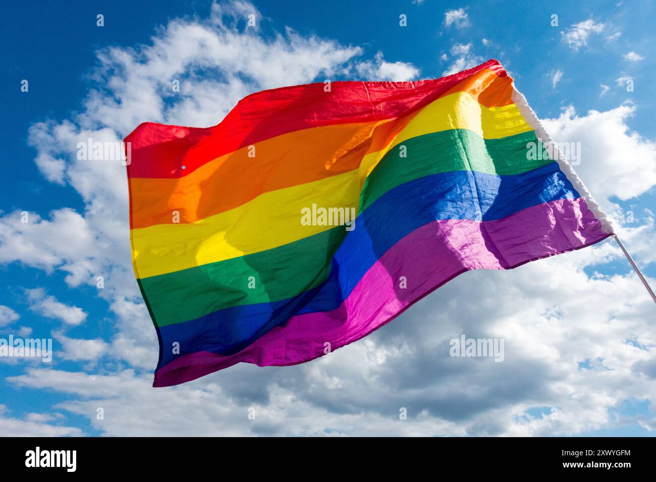 LGBT flag trans LGBTQ flag is blowing in the blue sky Stock Photo - Alamy