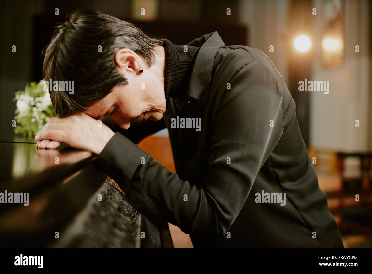 Female mourner saying last goodbye while crying on coffin Stock Photo ...