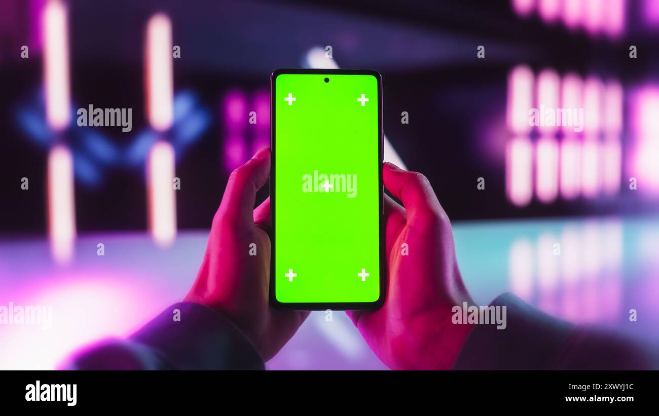 Anonymous Gamer Holding Smartphone Vertically with Green Screen Mock Up ...