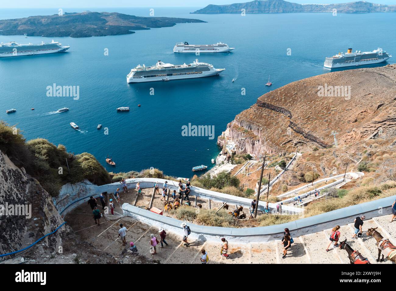 Santorini, Greece - October 8, 2019: Tourists traverse cliffside paths ...