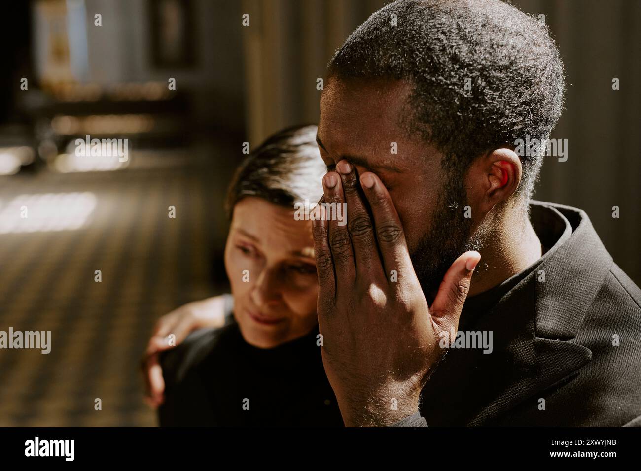 High angle shot of African American man hugging his mother while crying ...
