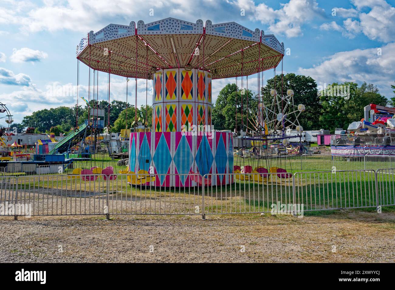 Old carnival rides being set up at the fair with the large swing and ...