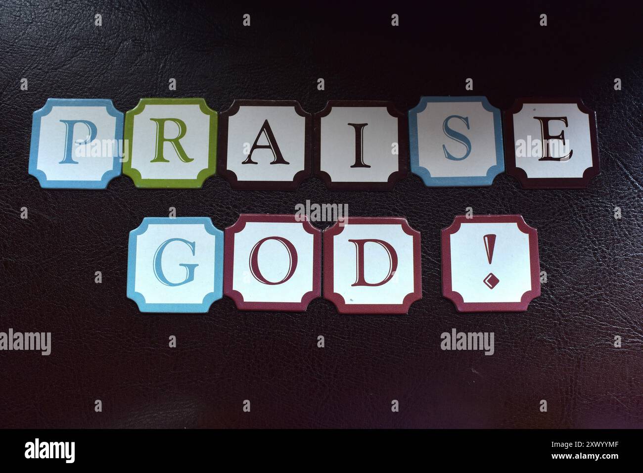 The words PRAISE GOD! formed with block style letters on a dark ...