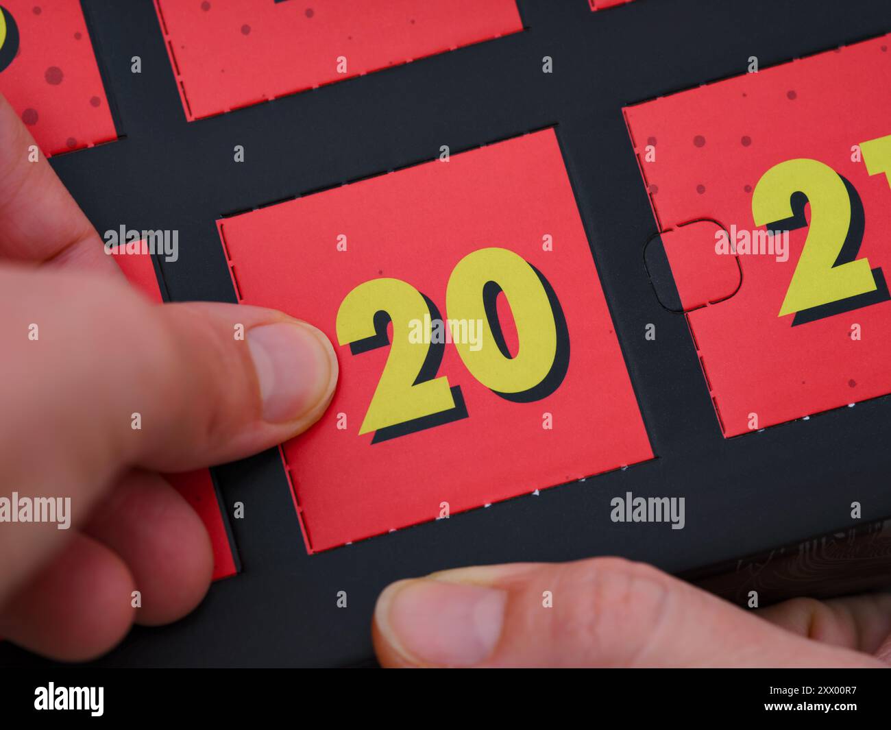 A woman hand ready to open the door with number 20 on the advent ...