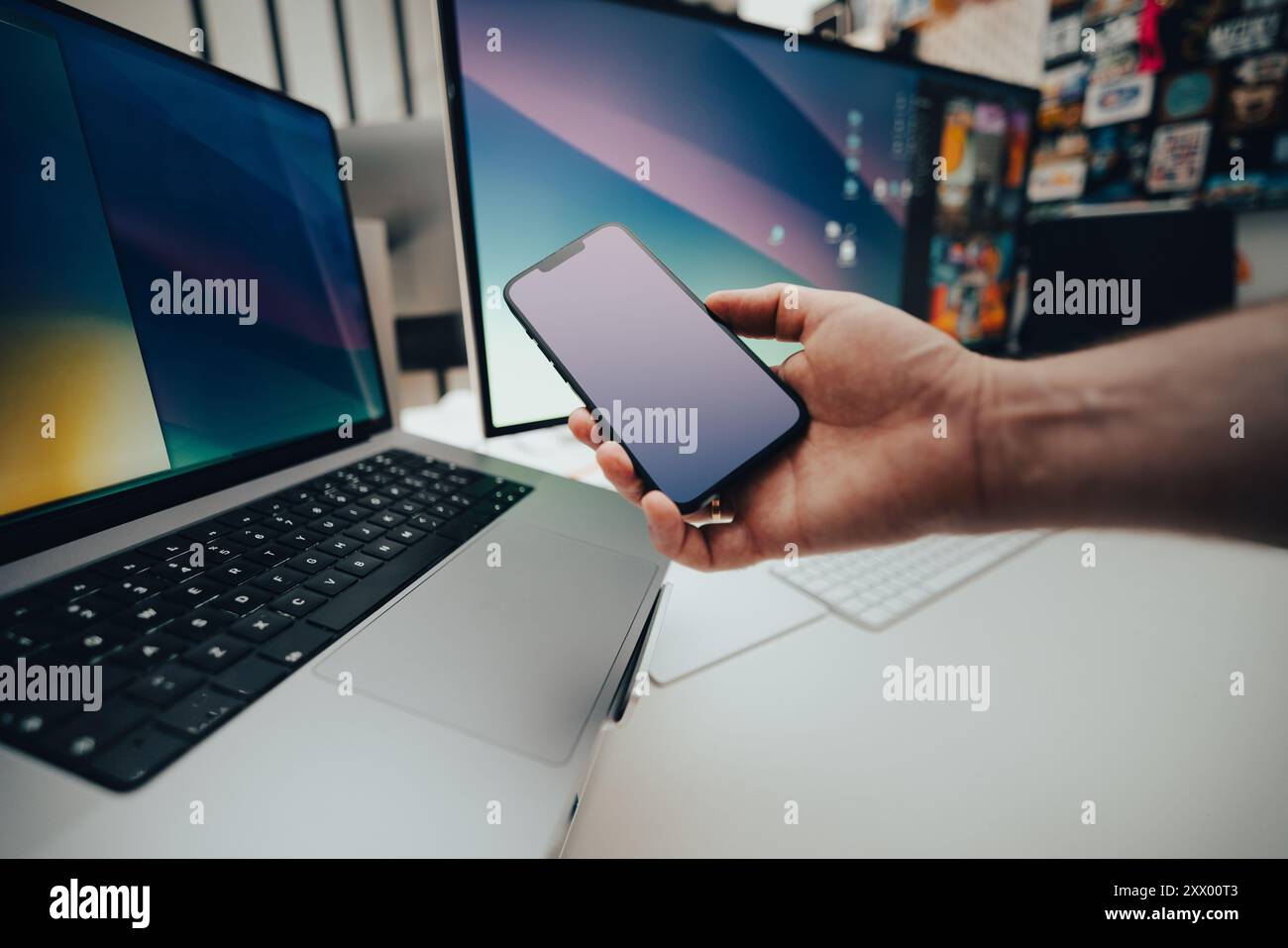 Office smart equipment interior. Hand holding phone. Laptop computer ...