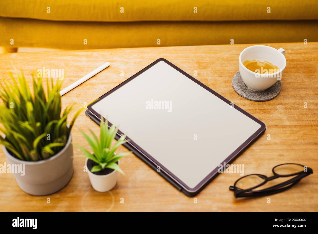 Tablet lying on raw wooden table. Home warm interior. Clean blank white ...