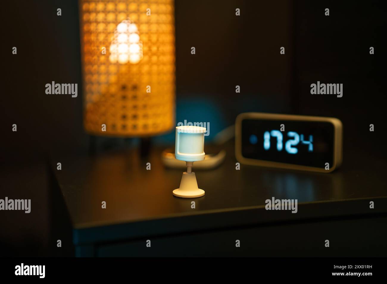 Smart home motion sensor. Bedside table with alarm clock and lamp. Home ...