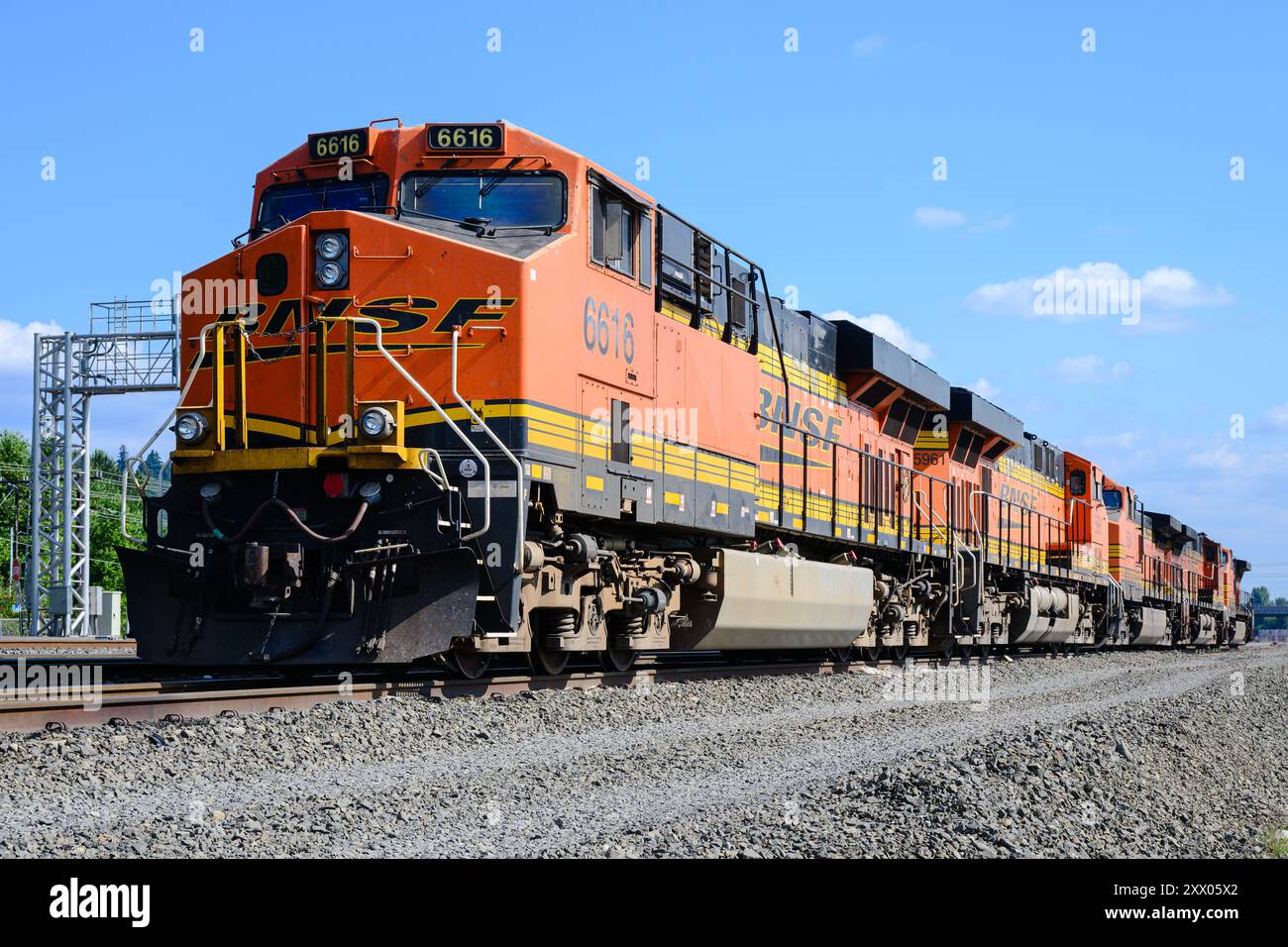 Seattle - August 14, 2024; BNSF freight train locomotives in line waiting duty under blue sky ...