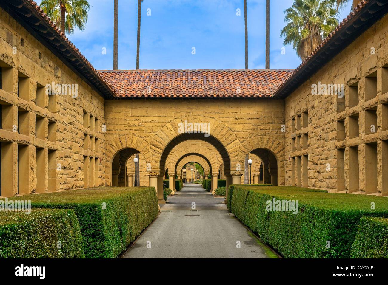 SPANISH STYLED STONE BUILDING WITH A TILED ROOF AND HEDGES WITH A NICE ...