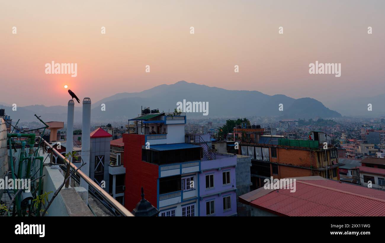 A beautiful sunset over the cityscape with mountains in the background ...