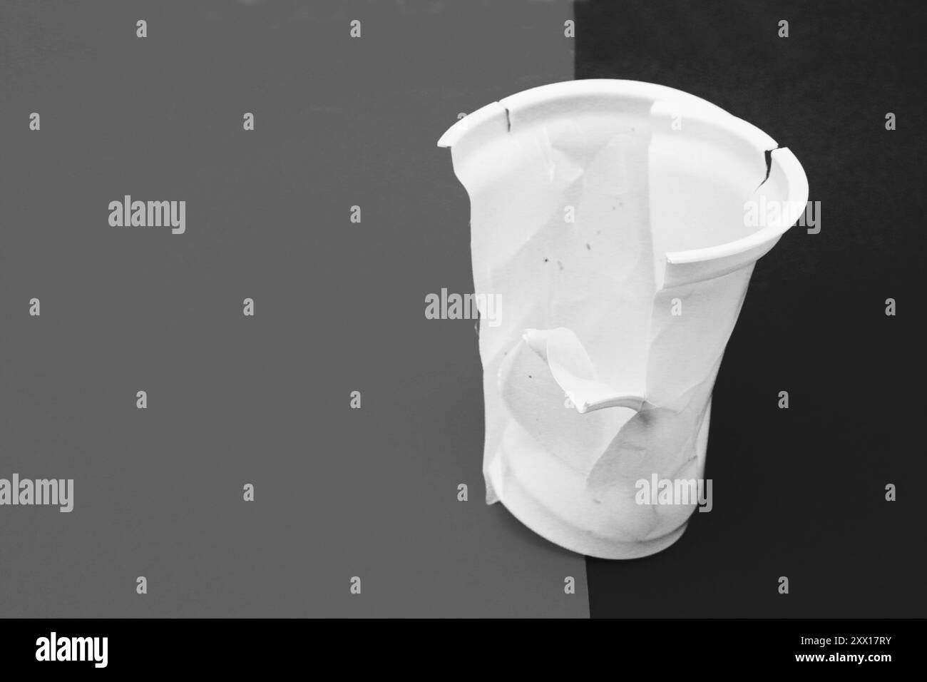 Damaged plastic cup on paper background Stock Photo - Alamy