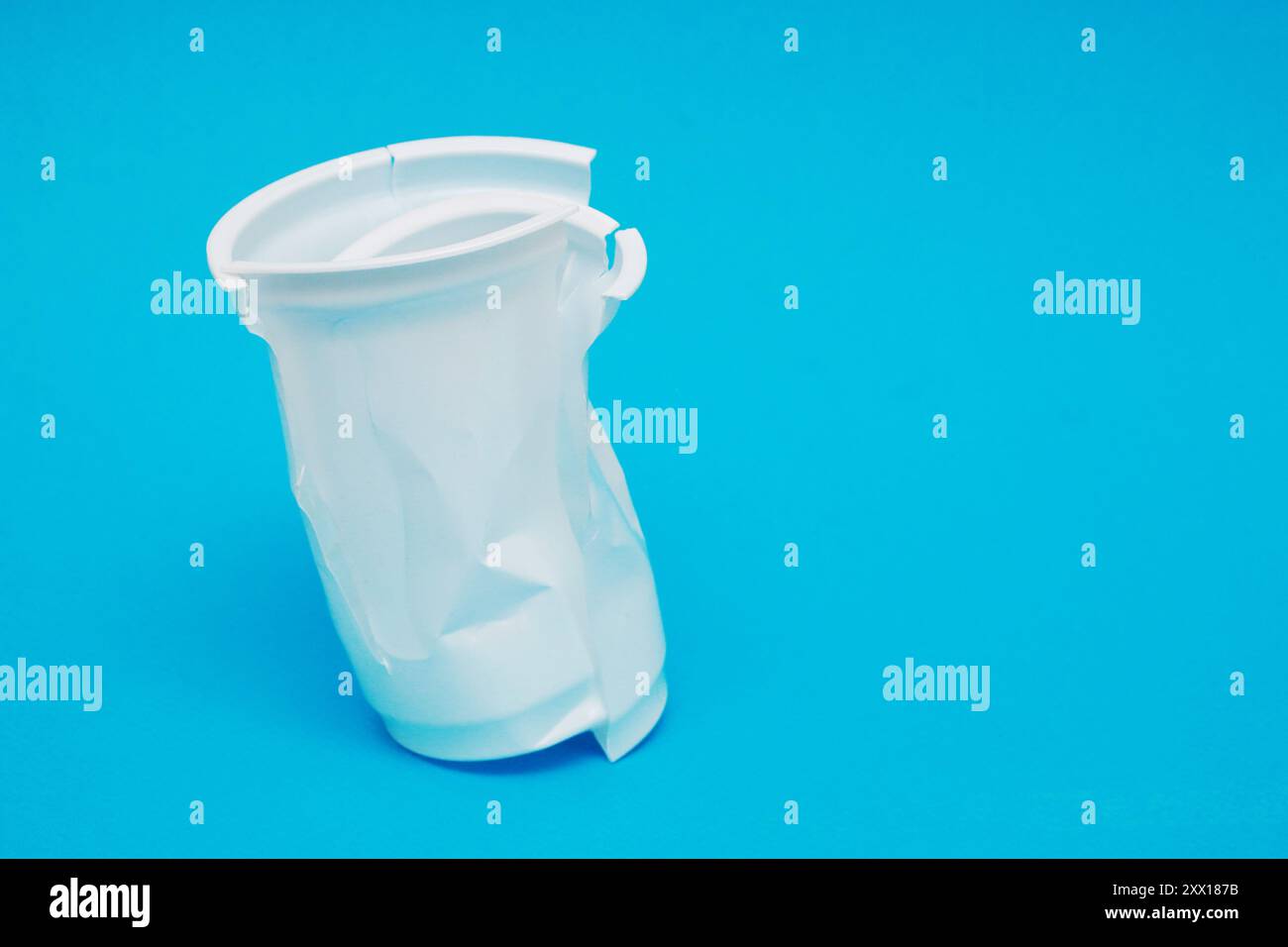 White plastic damaged drink glass on blue background Stock Photo - Alamy