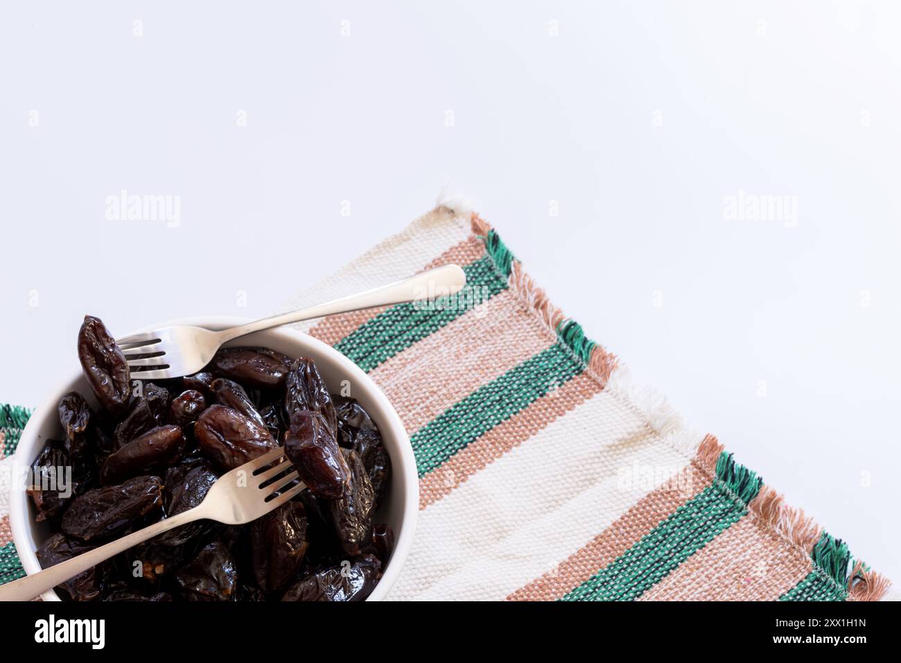 Bowl with portion of dried dates and forks with dates on top of this ...