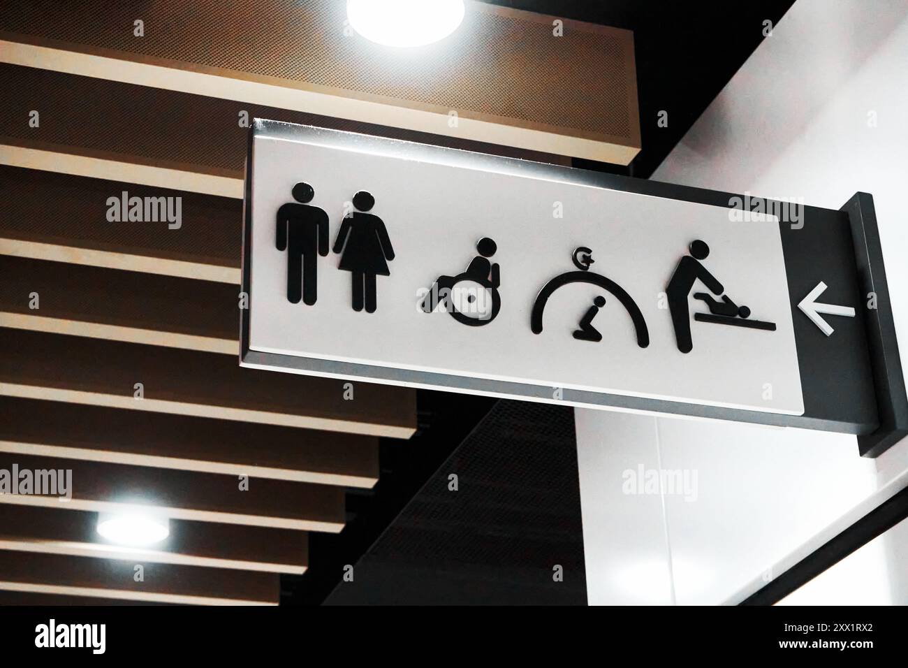 A white and black sign for the toilet and prayer room is on the wall ...
