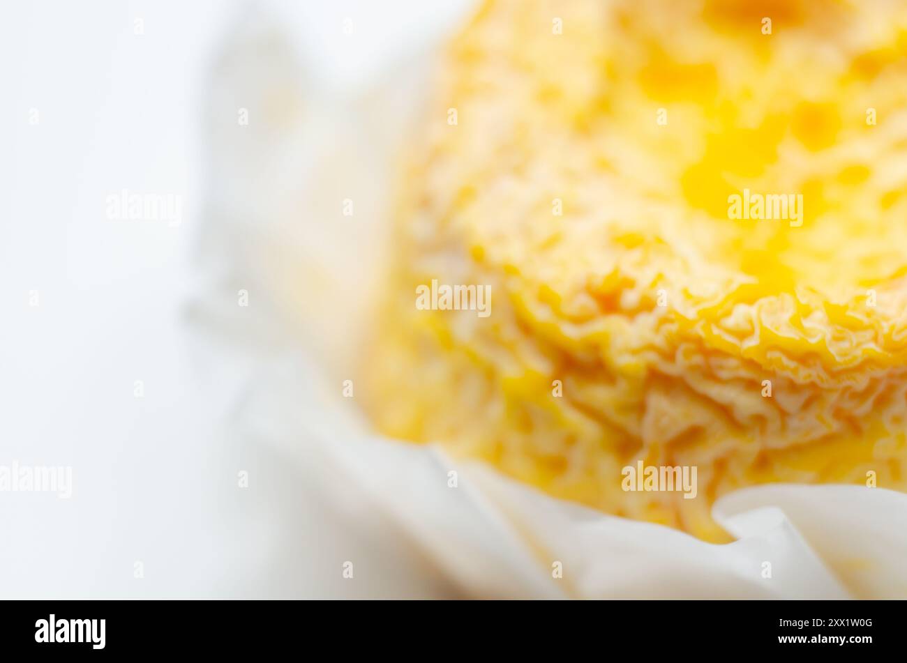 A yellow cheese is sitting in a paper wrapper, popular soft french ...