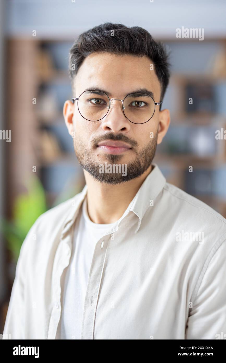 Vertical close-up portrait of a young Indian man in glasses and shirt ...