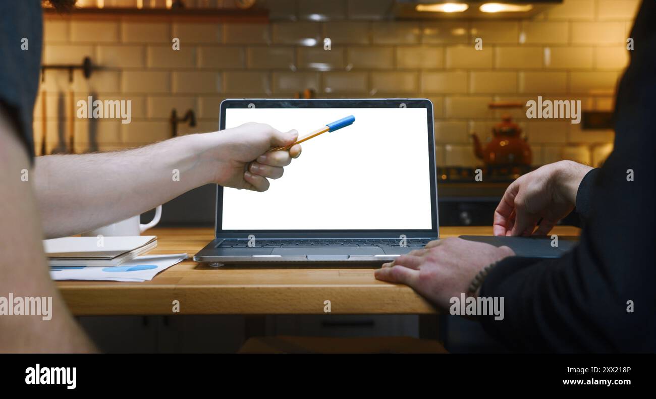 Two anonymous men working with laptop computer with white mock up ...