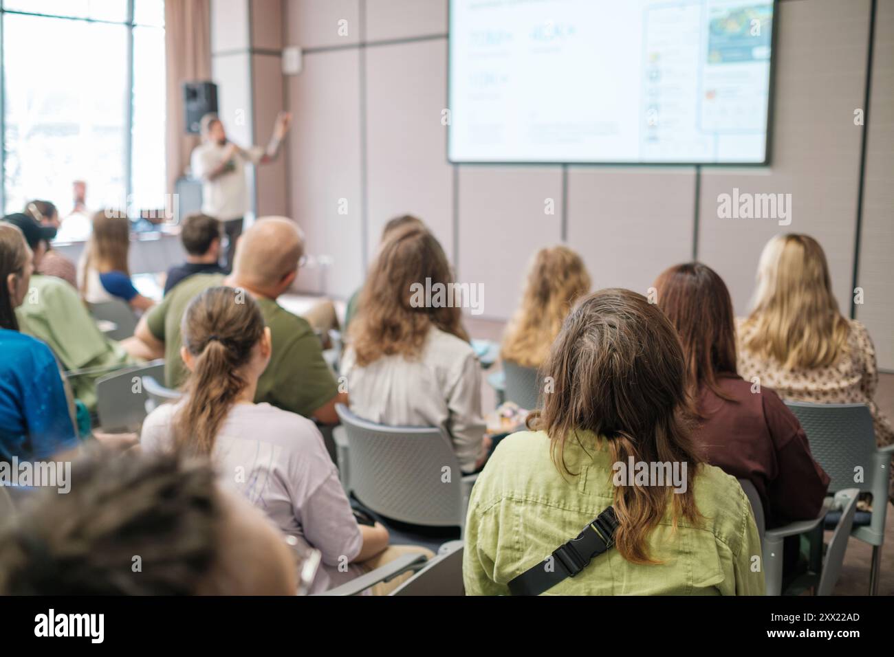 Conference room filled with attentive participants listening to ...
