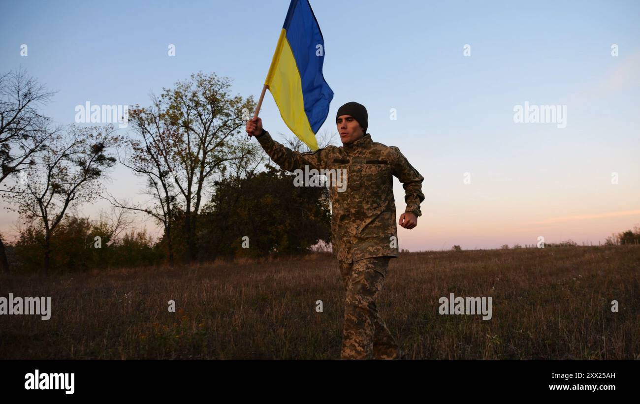Soldier of ukrainian army running with raised blue-yellow banner on ...