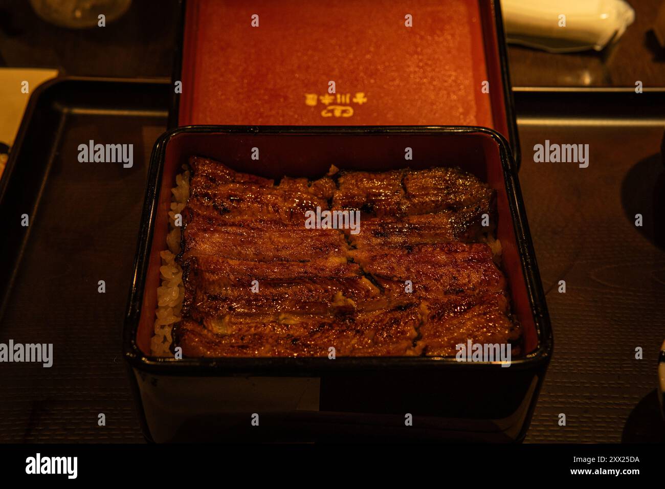 Traditional Japanese unagi don—grilled eel served over rice in a ...