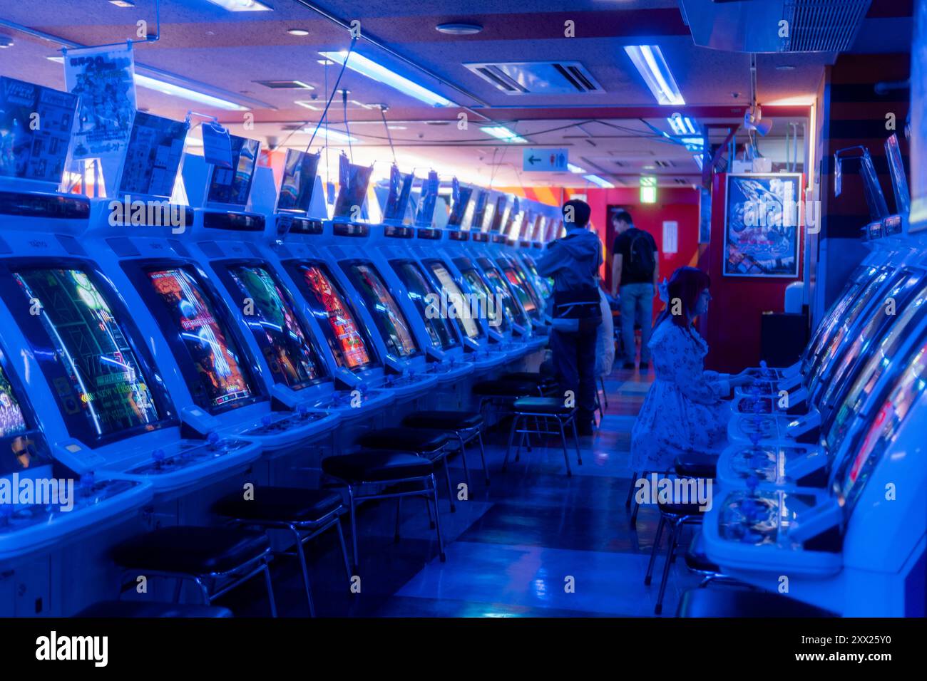 Rows of brightly lit arcade machines in Tokyo, Japan, glowing with blue ...