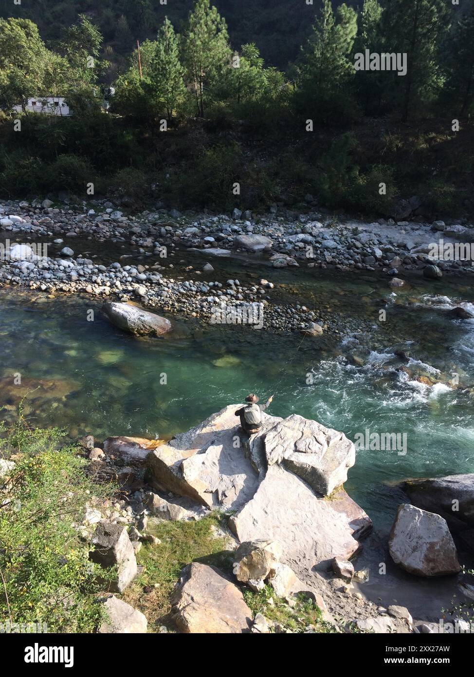 Overhead view of a Man trout fishing in the Tirthan River, Himachal ...