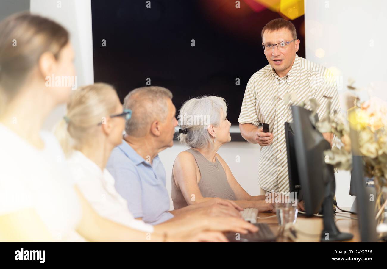 Male instructor leading computer session for older adults Stock Photo ...