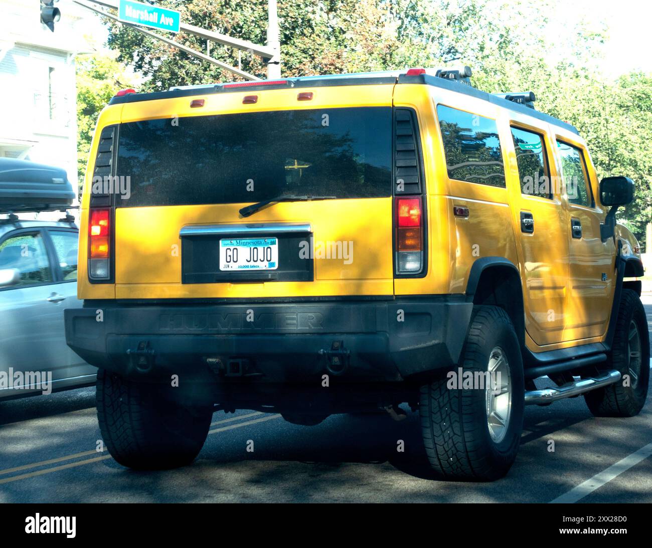 Large yellow Hummer SUV with a "GO JOJO" designer license plate. St ...