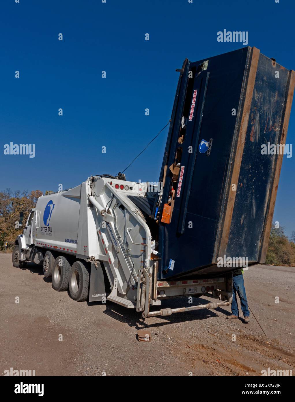 Large junkyard dumpster being emptied into a garbage truck for disposal ...