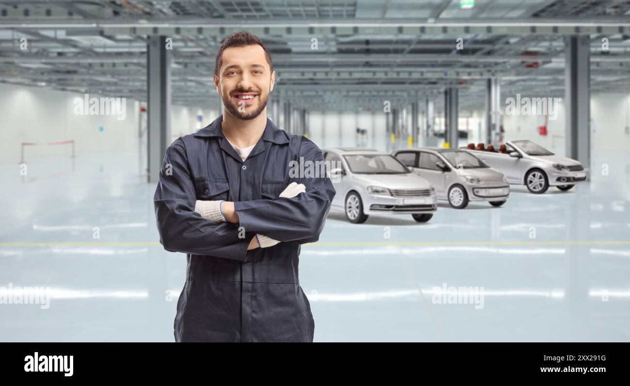 Car mechanic standing in a car garage Stock Photo - Alamy