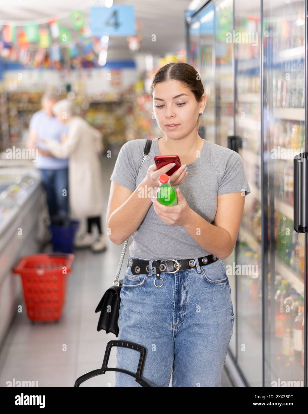 Woman purchaser scanning label of cool drink by phone Stock Photo - Alamy