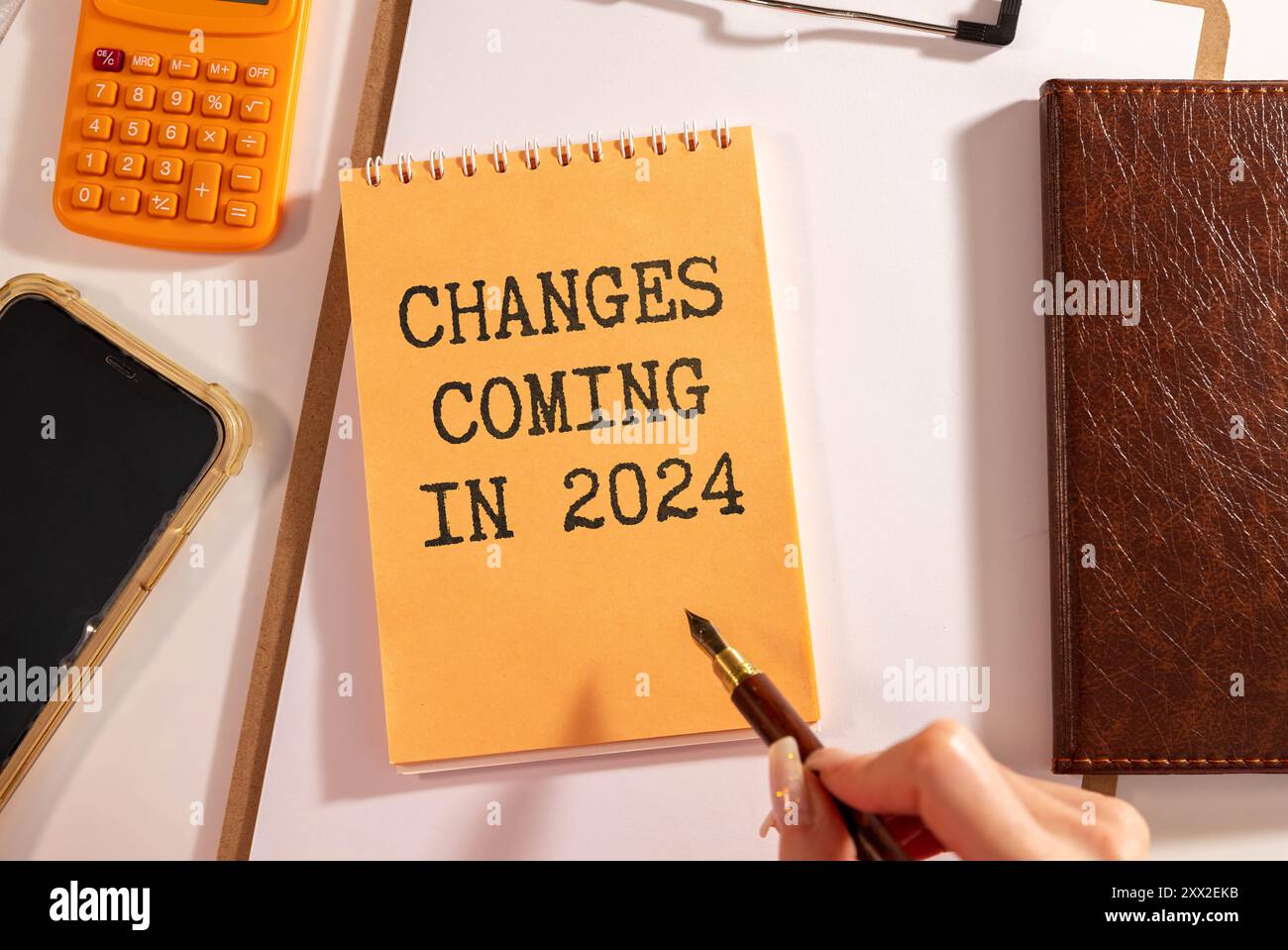 White notepad with text CHANGES COMING IN 2024 and office tools on the ...