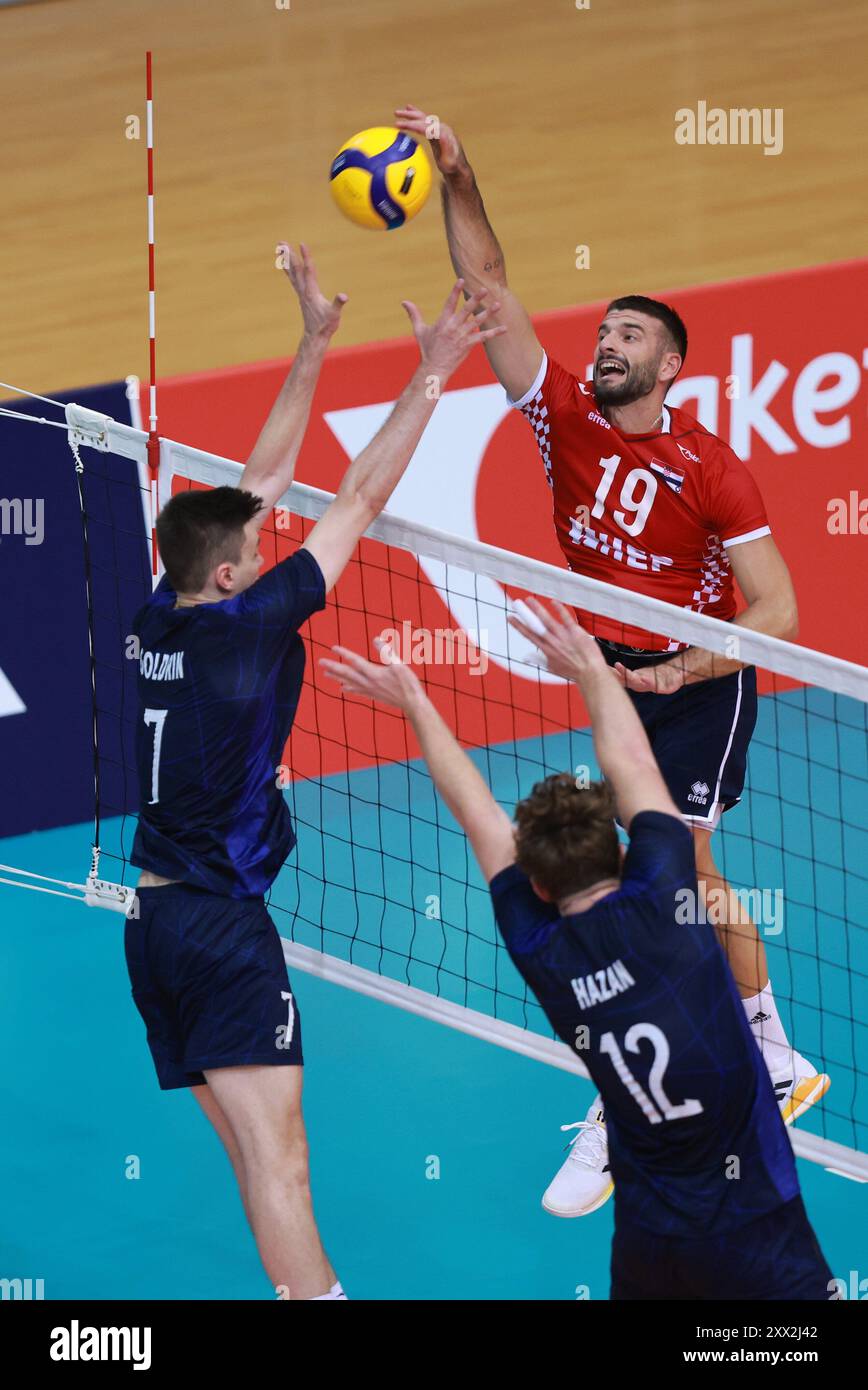 Osijek, Croatia. 21st Aug, 2024. Ivan Zeljkovic (R) of Croatia spikes ...