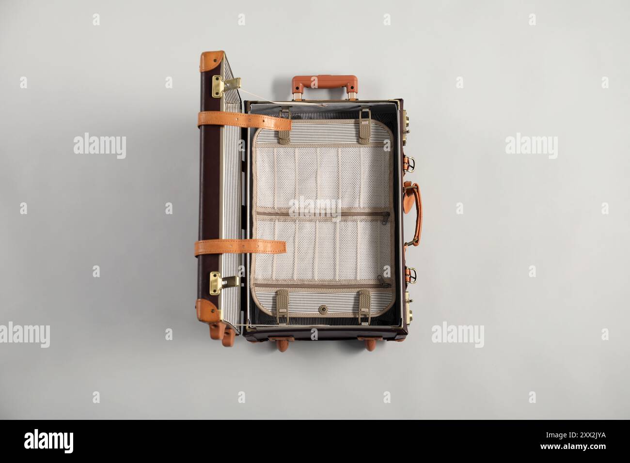 Open empty suitcase on light grey background, top view. Space for text ...