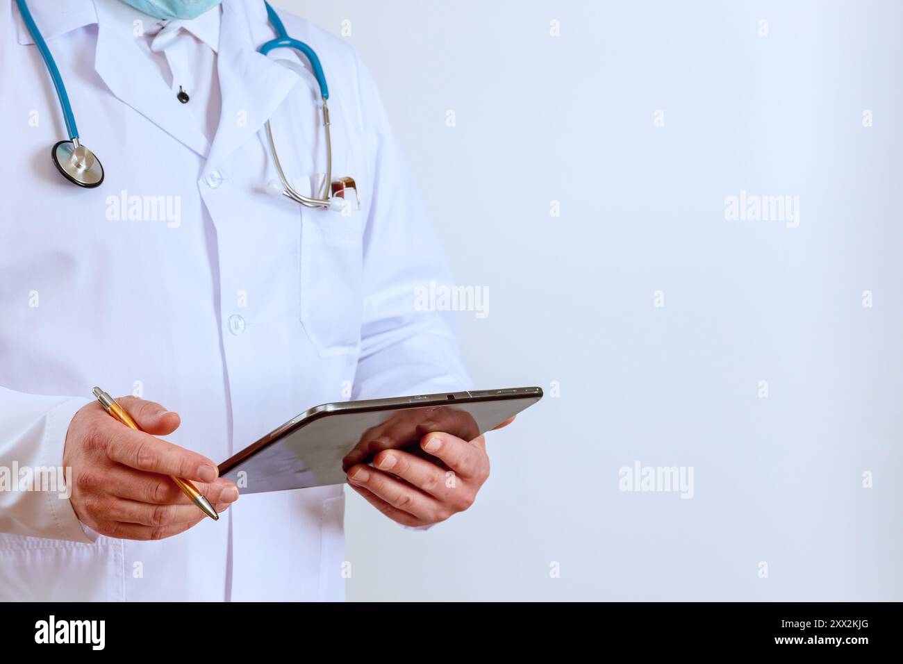 Healthcare doctor takes notes in digital tablet recording patient ...