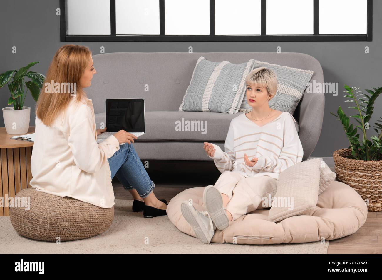Sad teenage girl talking to psychologist in office Stock Photo - Alamy