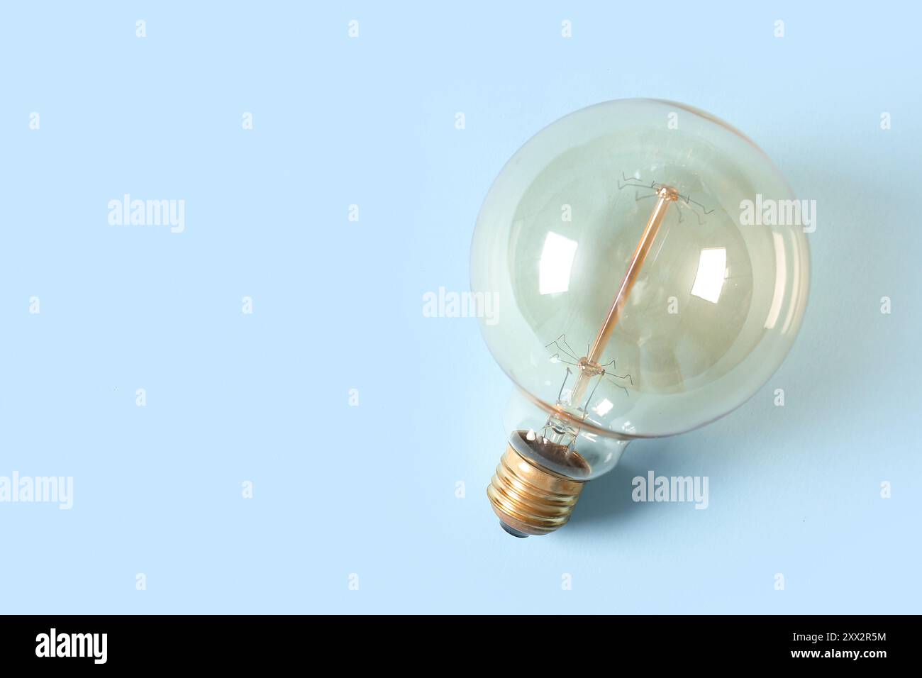 Round retro light bulb on blue background Stock Photo - Alamy