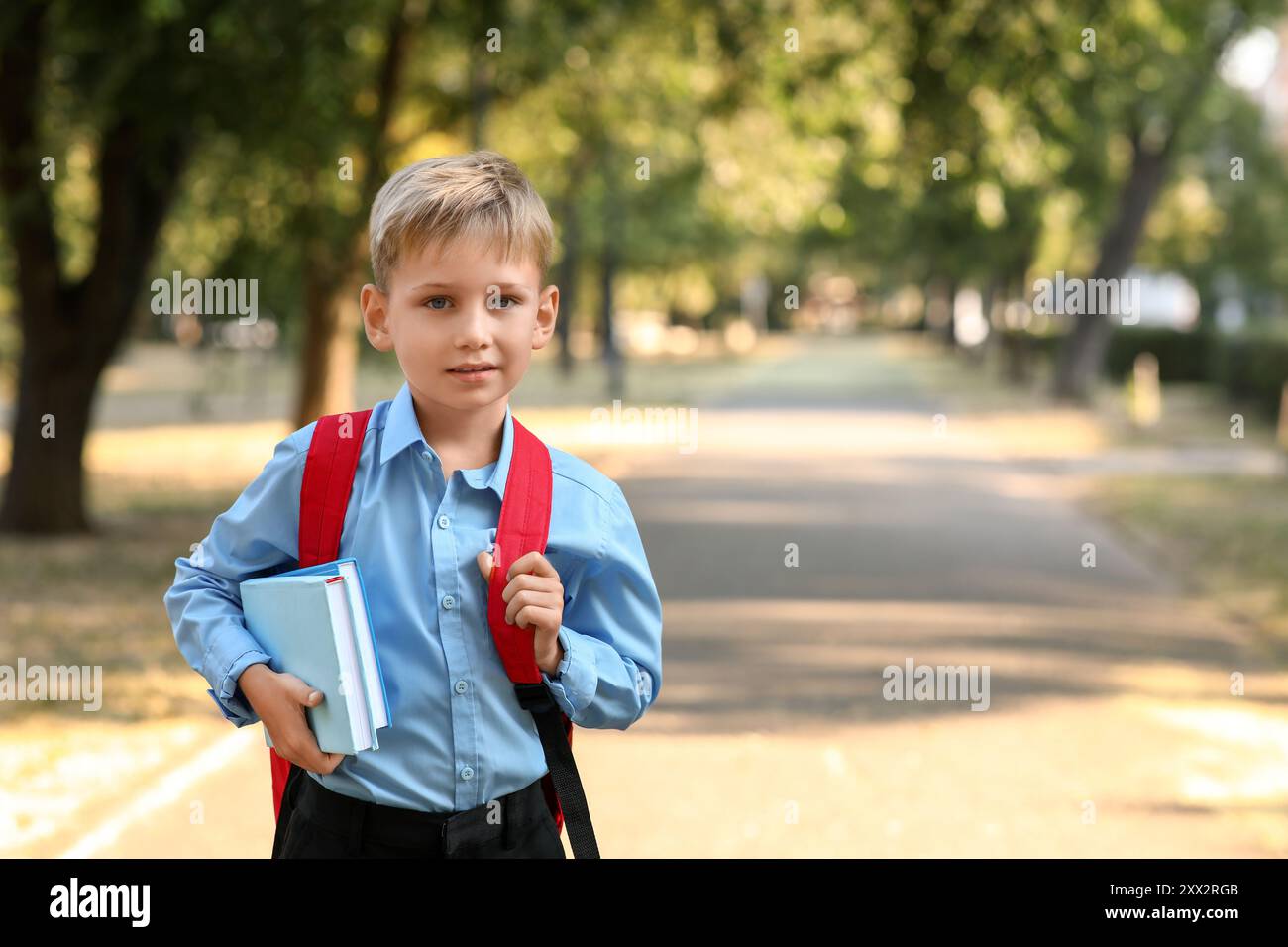 Cute little boy with backpack and books outdoors Stock Photo - Alamy